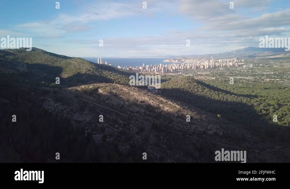 Drone footage of mountain revealing Benidorm Stock Video Footage - Alamy