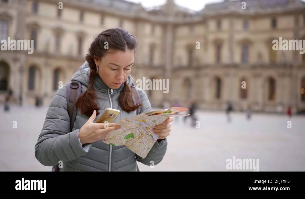 Lost female tourist using two maps two find a way in new city, woman ...