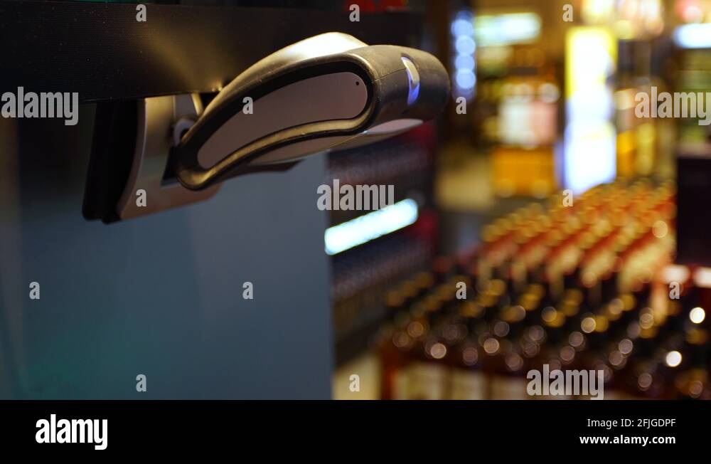 Scanning barcode at wine bottle using modern device in supermarket ...