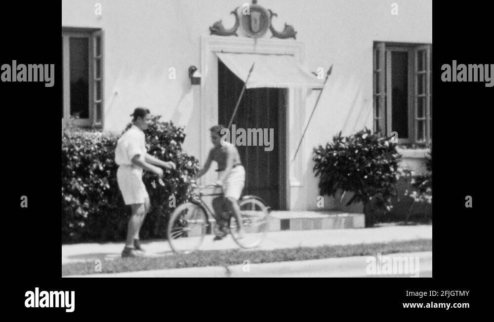 1940s: Young man rides past house on bike. Young man rings doorbell ...