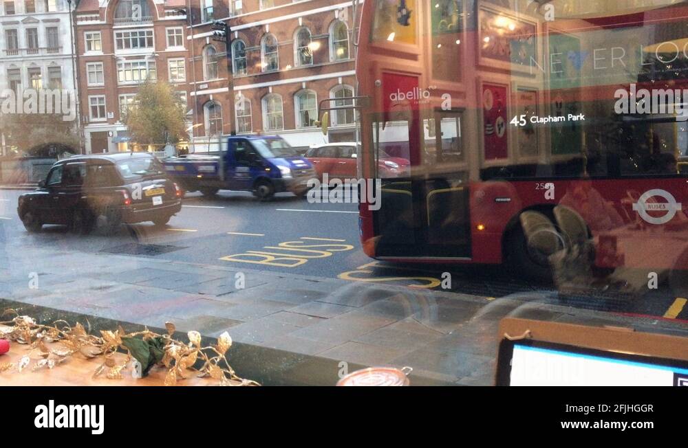Double-decker bus pulling away, seen from inside a restaurant Stock ...