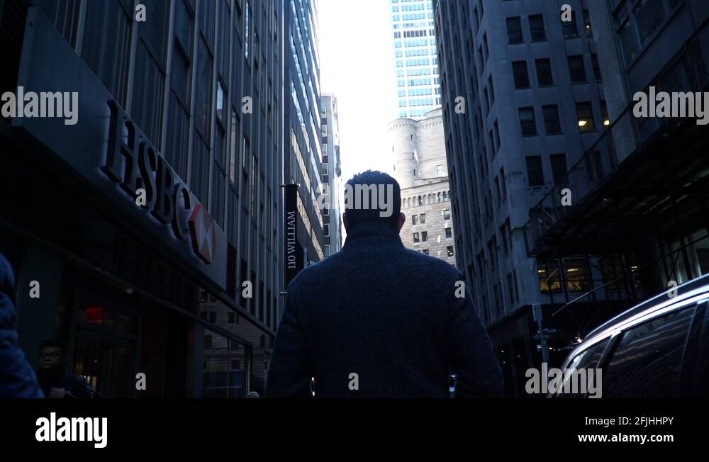 Tall business man walking on a busy street on Manhattan to work. Slow ...