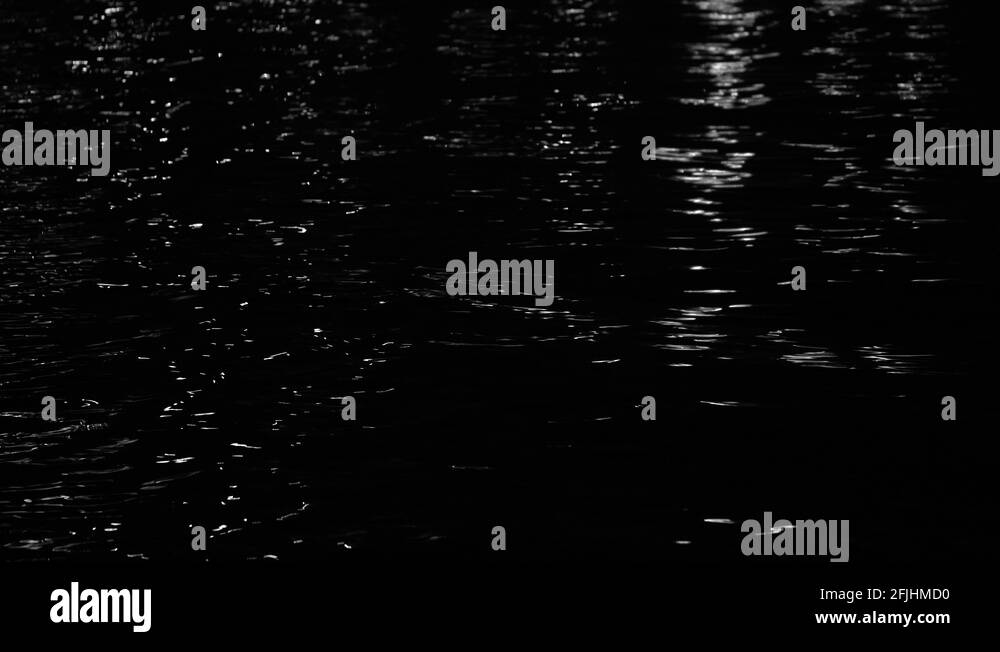 Black night sea water background with light reflections on calm surface ...