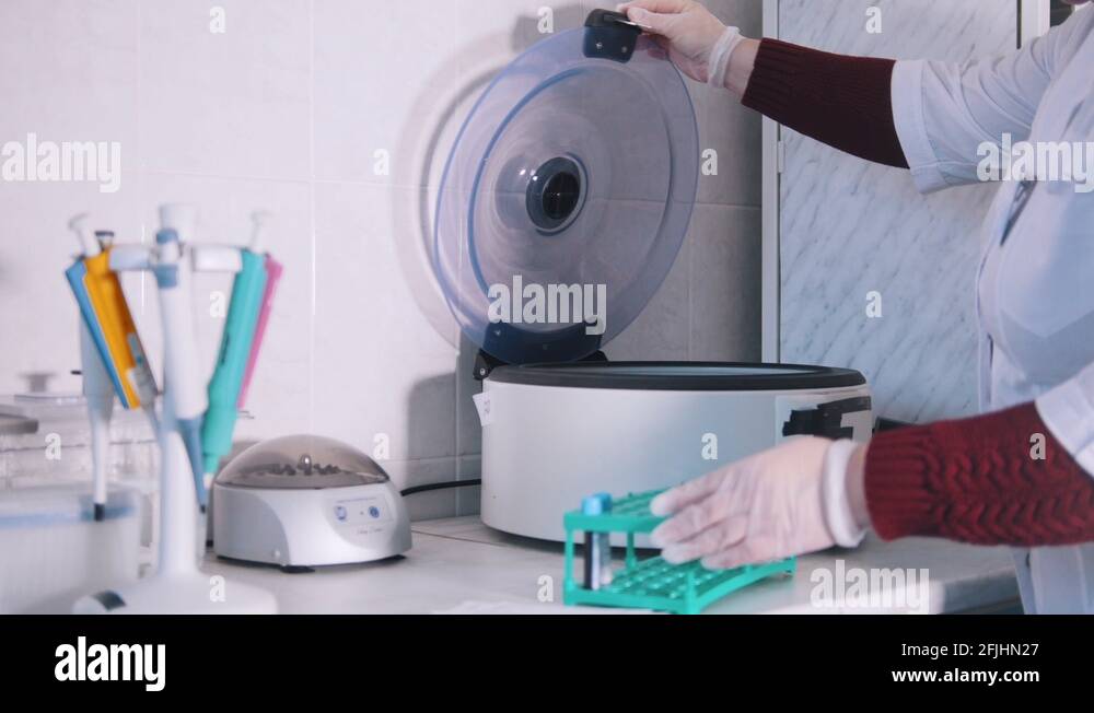 Medical clinic. Nurse putting blood samples in the blood centrifuge ...