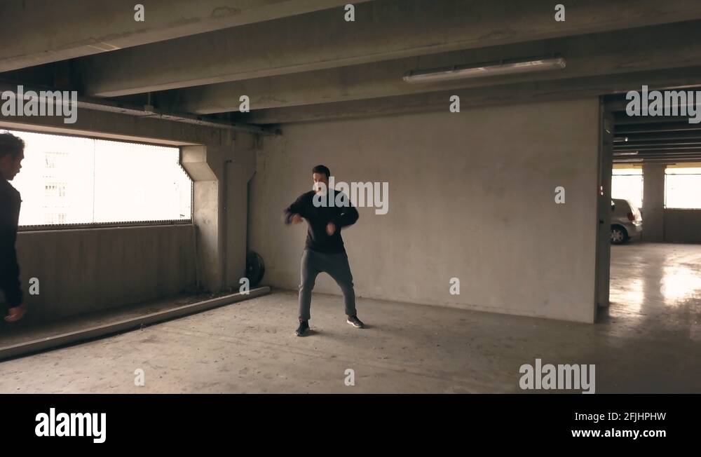 Man takes fighting stance with back to a plain wall and is attacked by ...