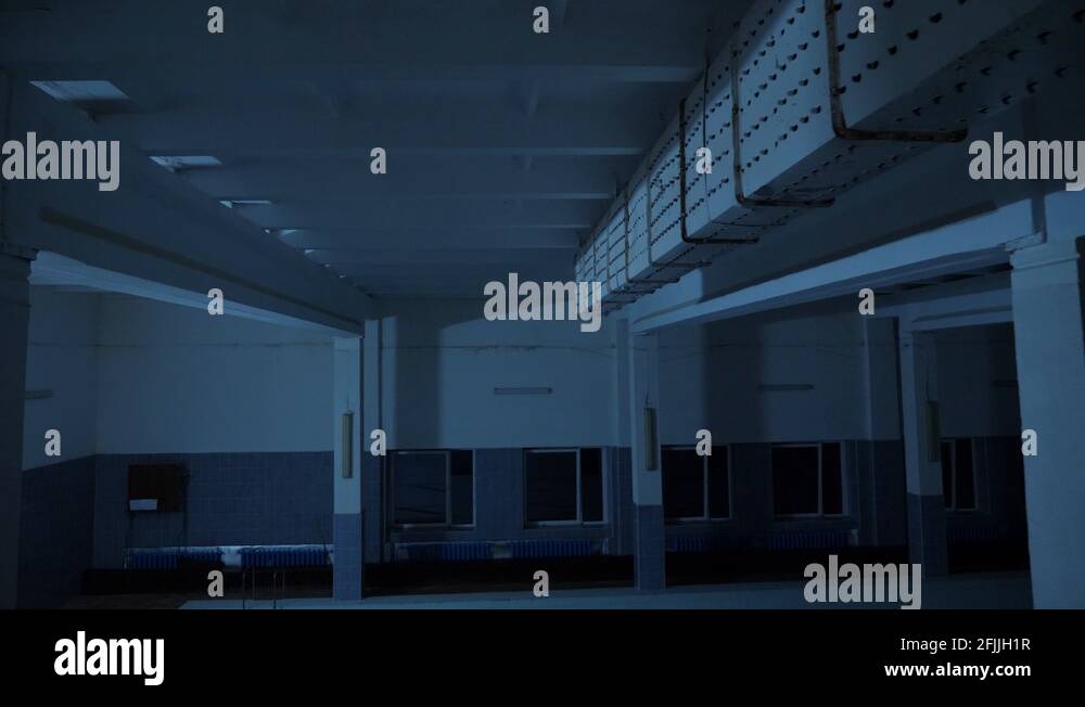 Empty indoor swimming pool drained with no water in an old school or ...