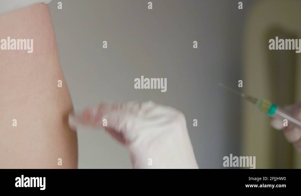 Close-up of the hand of a medic administering an intramuscular ...