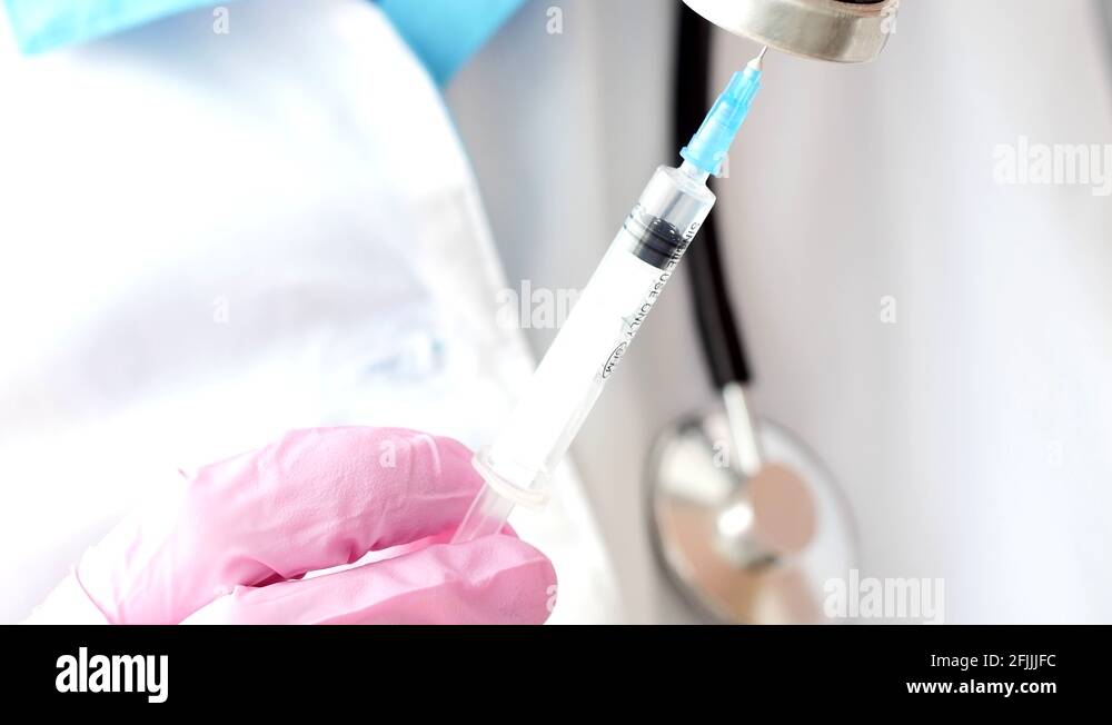 Medical doctor picking up medication into a single use syringe Stock ...