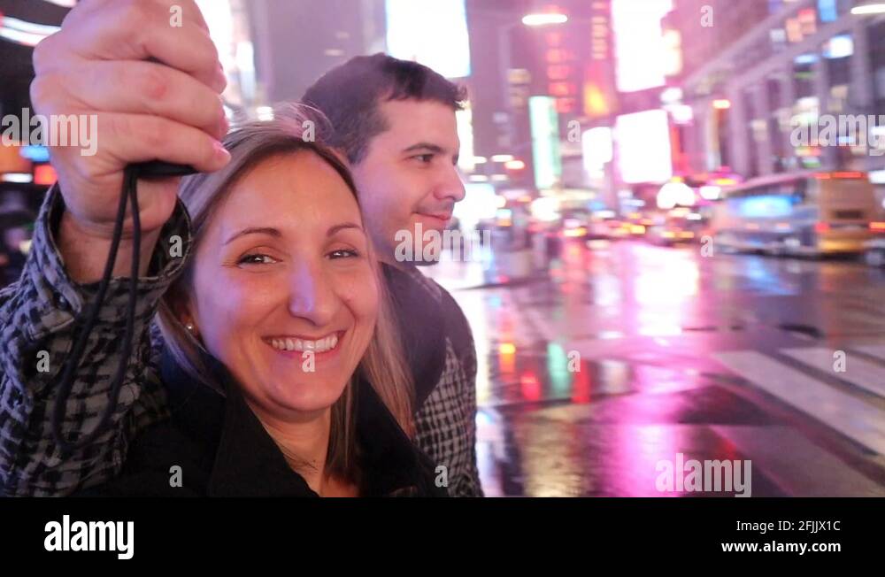 Attractive couple kissing in Times Square in New York City in the rain ...