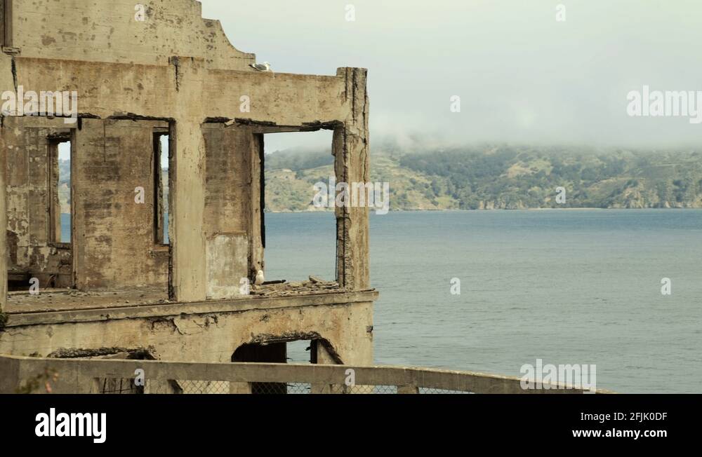 Old destroyed Building on Alcatraz island with ocean and misty shore in ...