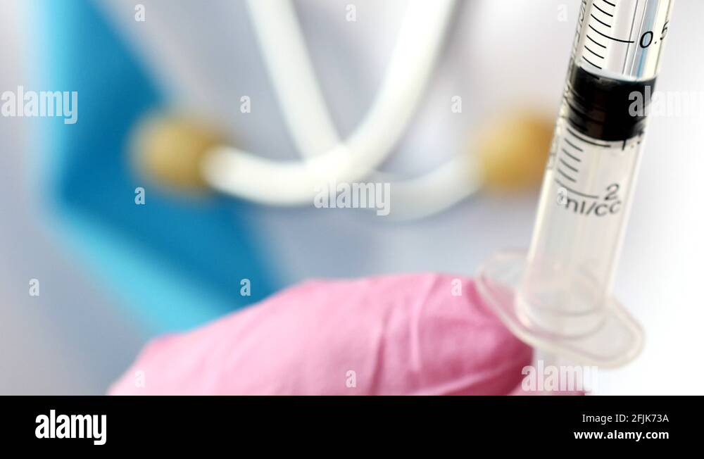 Medical doctor picking up medication into a single use syringe Stock ...