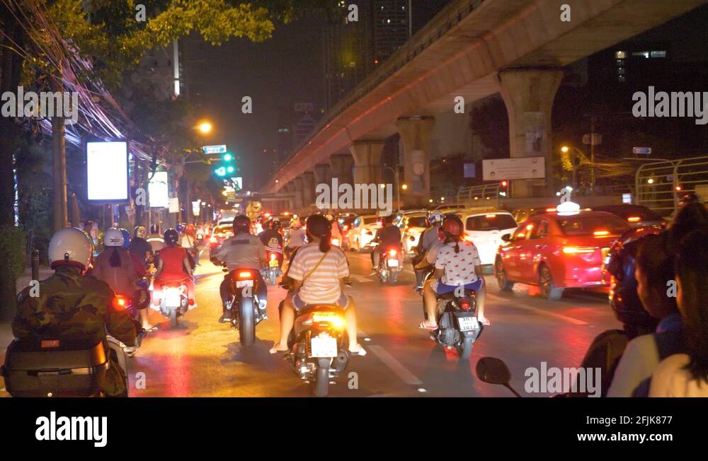 Scooters driving at night in busy traffic in Bangkok, Thailand Stock ...