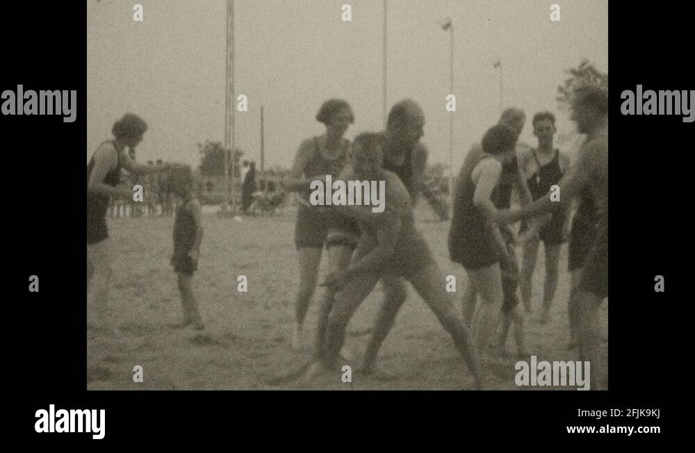 1920s: Men wrestle. People run around and play. Man and woman clasp ...