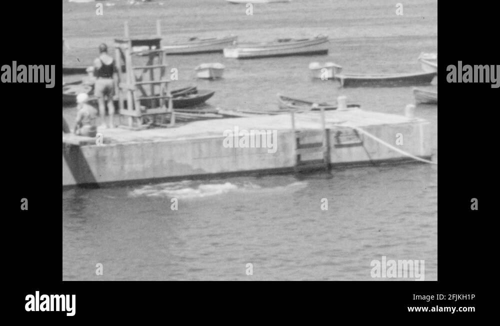 1940s: Boys jump into water, swim towards ladder, climb it up to ...