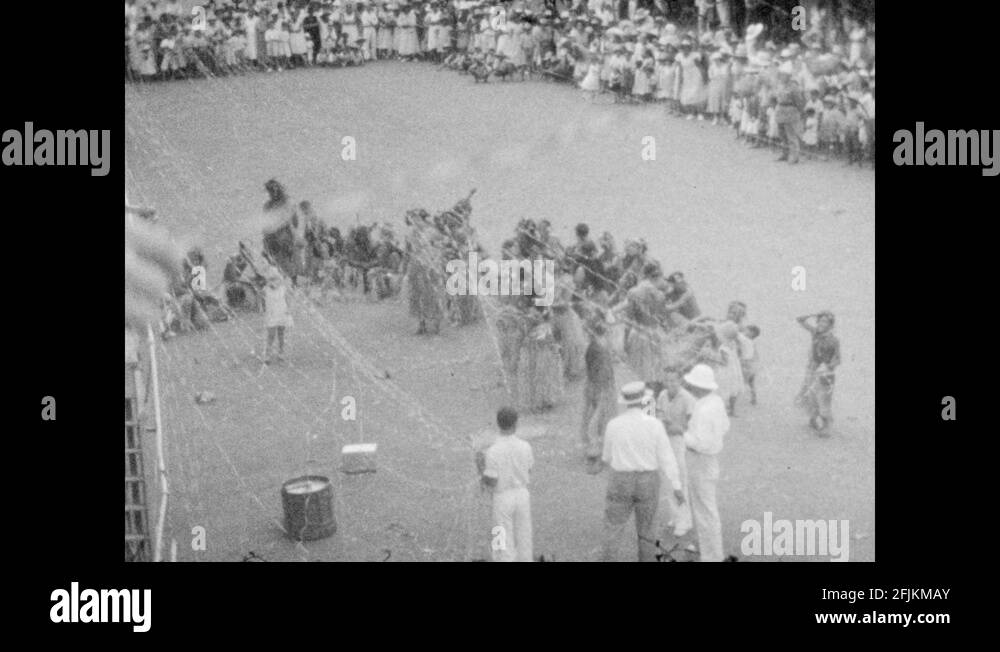 1940s: Dense crowd watches, dancers in native dress hold strings ...