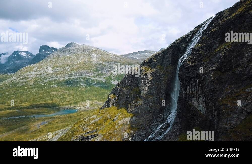 Zooming in to a stunning dramatic waterfall on a steep vertical cliff ...