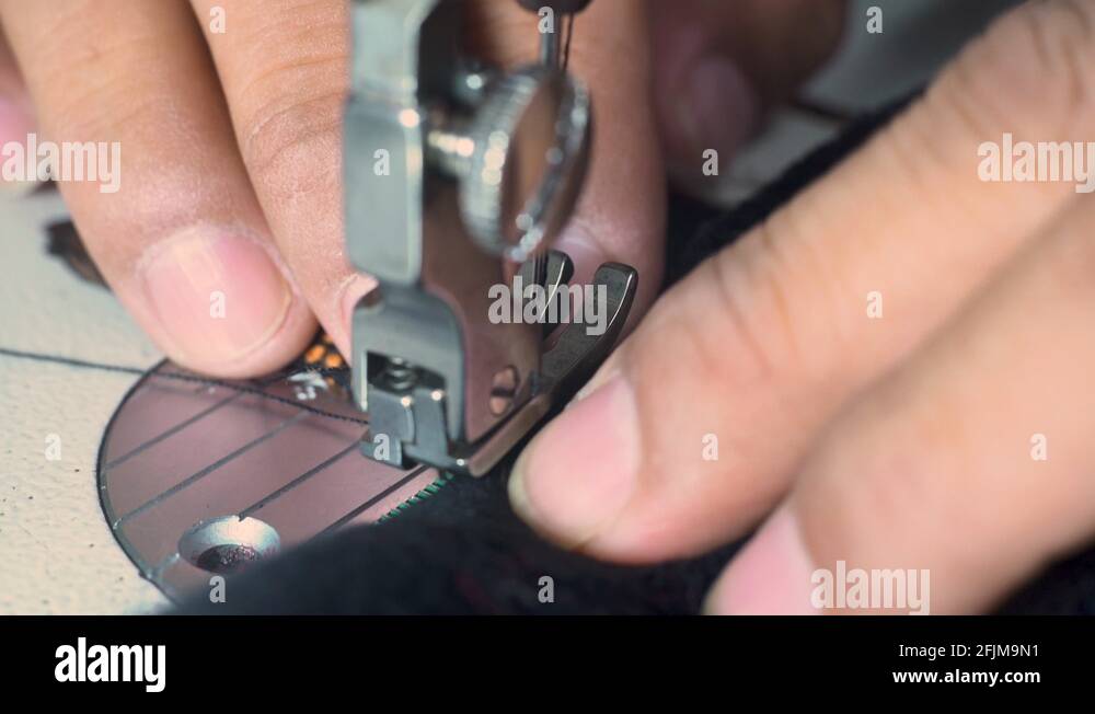 Macro up close seamstress using sewing machine needle stabbing two ...