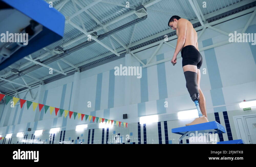 A male with a prosthetic leg is preparing to swim in a pool Stock Video ...