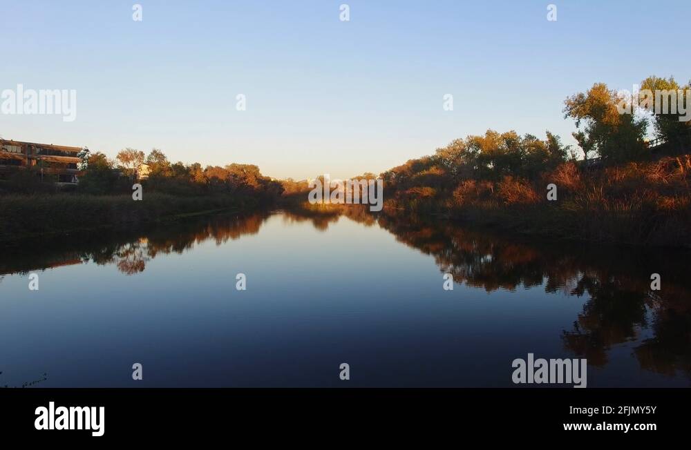 Sunset light on edges of river banks as shadow of train passes by Stock ...