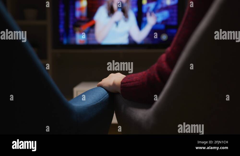 Holding hands while watching tv Stock Video Footage - Alamy