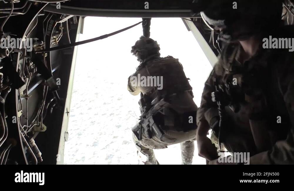 NATO special operations members conduct fast rope training out of a CV ...