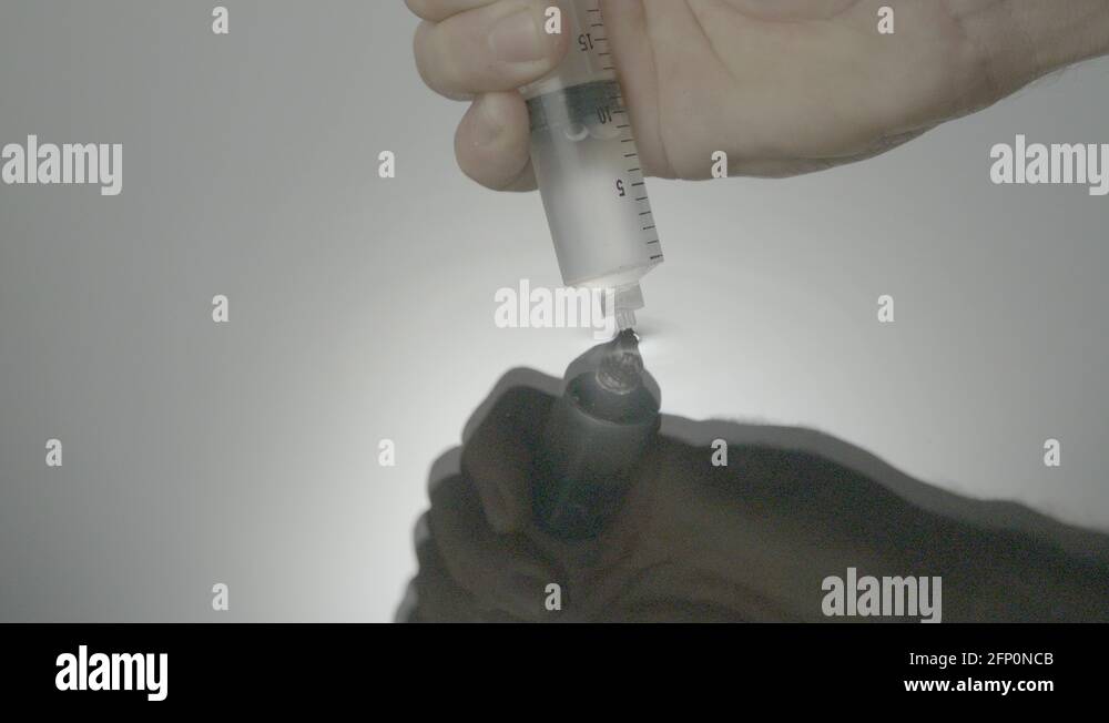 Syringe dripping into liquid Stock Video Footage - Alamy