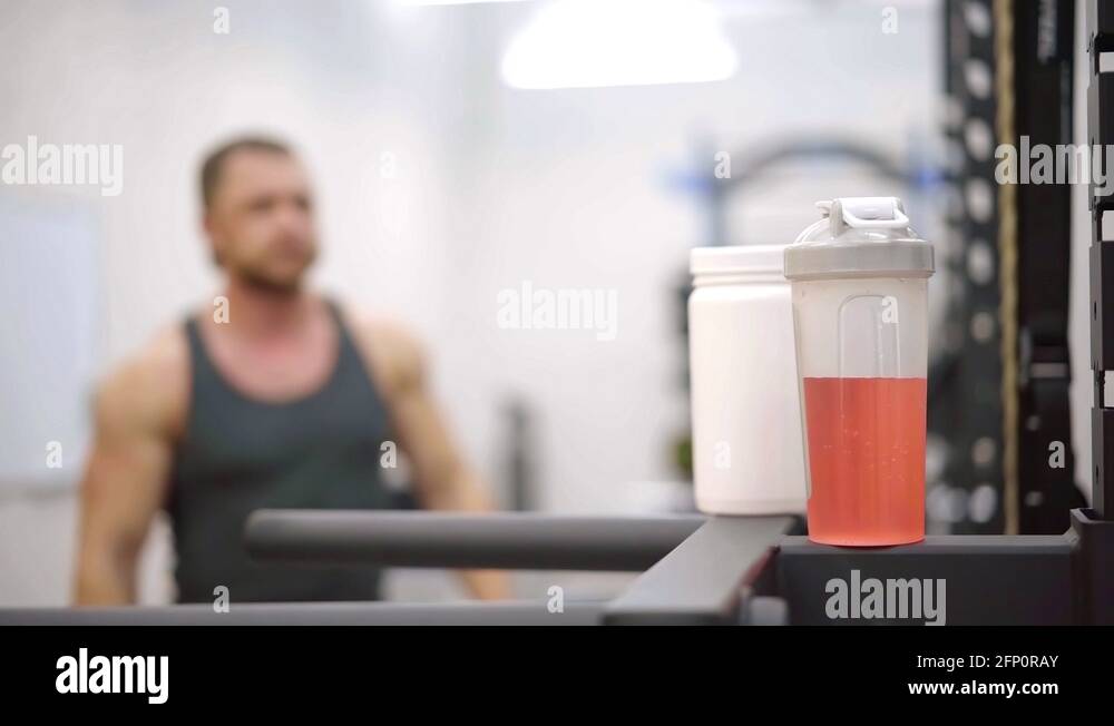 Big man walking to take a shaker with pink cocktail after a set in a ...