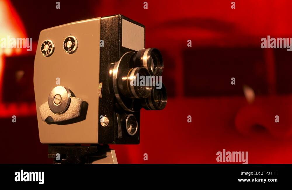 Vintage 8mm film camera rotating in front of flickering old movie Stock ...