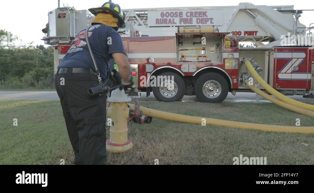 Firefighter unscrews a fire hydrant during emergency response training ...
