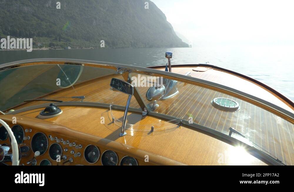 A woman on a classic luxury wooden runabout boat on an Italian lake ...