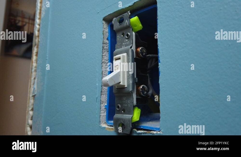 Pulling a switch out of a wall box and unscrewing and ring two wires ...