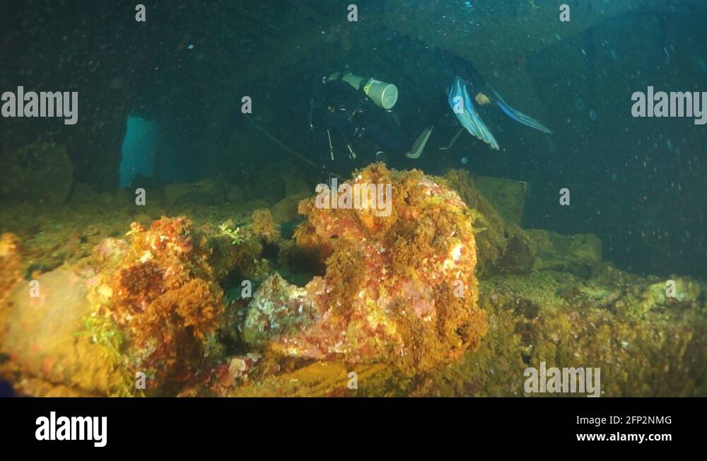 Diver inside hull of sunken ship underwater of Pacific Ocean on Chuuk ...