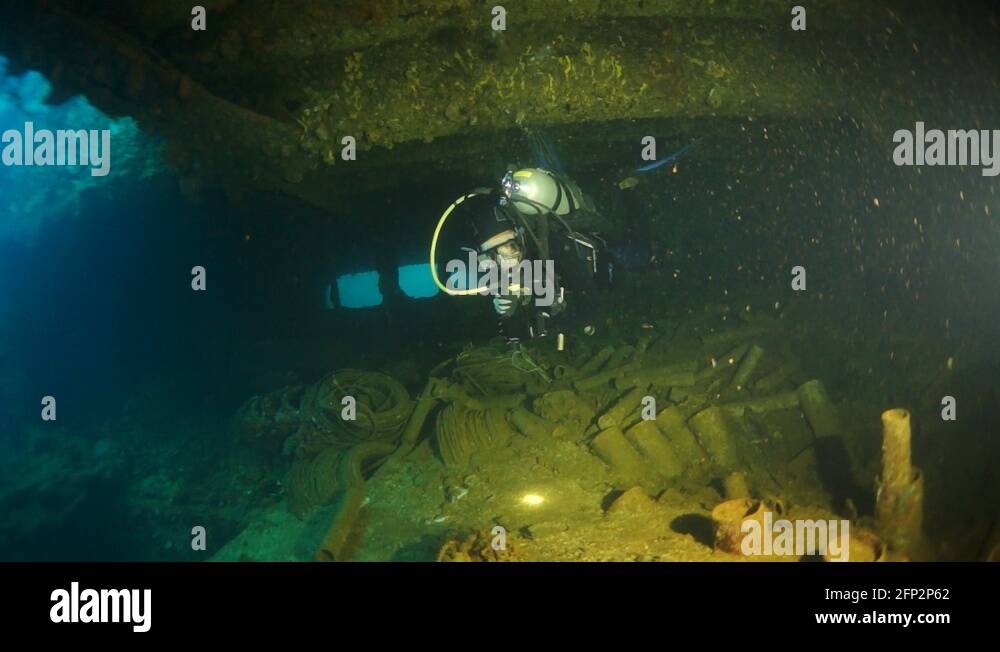 Diver inside hull of sunken ship underwater of Pacific Ocean on Chuuk ...