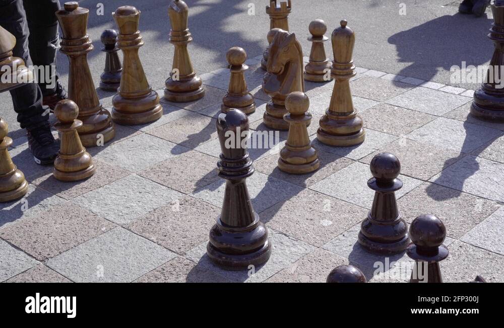 People playing and watching giant chess strategy game in public park of ...
