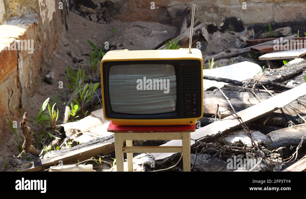 Small retro TV in house destroyed by fire flickering screen green ...
