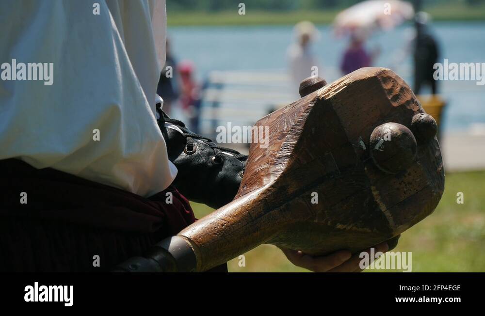 cossack toss up a big heavy wooden mace in hands outdoors on the summer ...