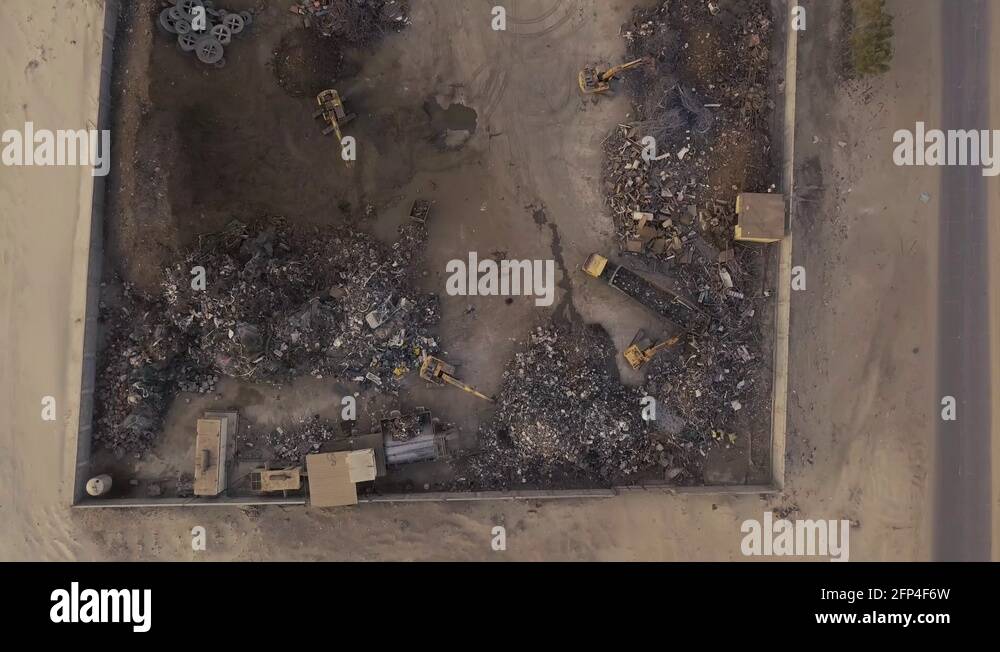 Scrapyard with excavators and dump trucks birds eye view (4K Stock ...