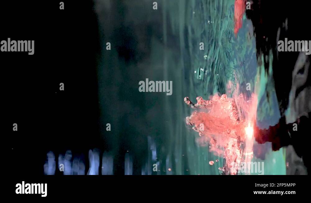 SLOW MOTION: Lit road flare submersed under water in pool with smoke ...