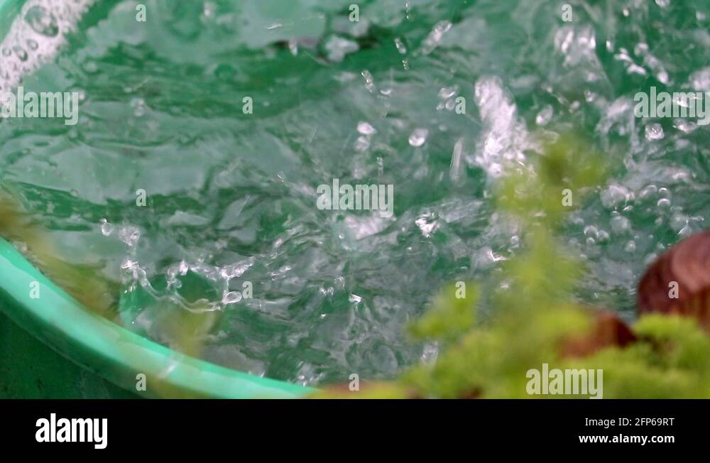 Slow Motion Clip Of Rainwater Splashing Into A Filled Plastic Bucket ...
