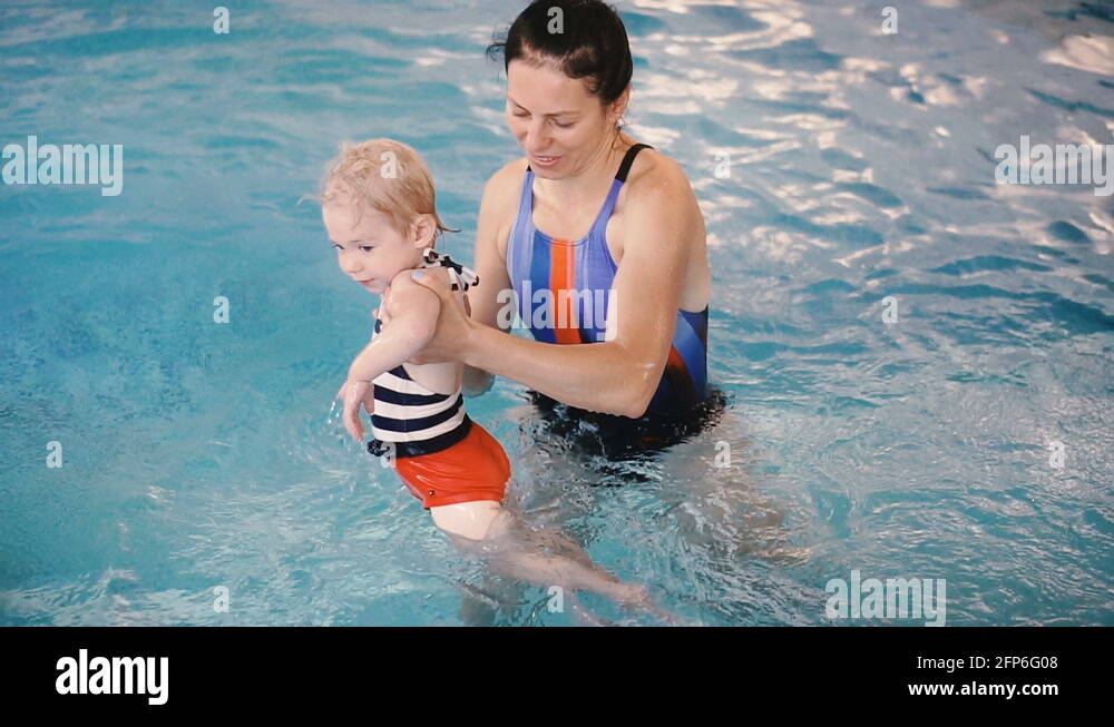 Swimming pool. Mom teaches a young child to swim in the pool Stock ...