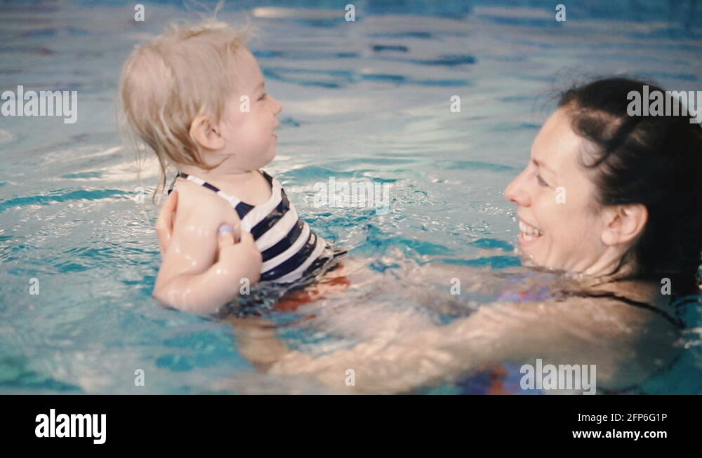 Swimming pool. Mom teaches a young child to swim in the pool Stock ...