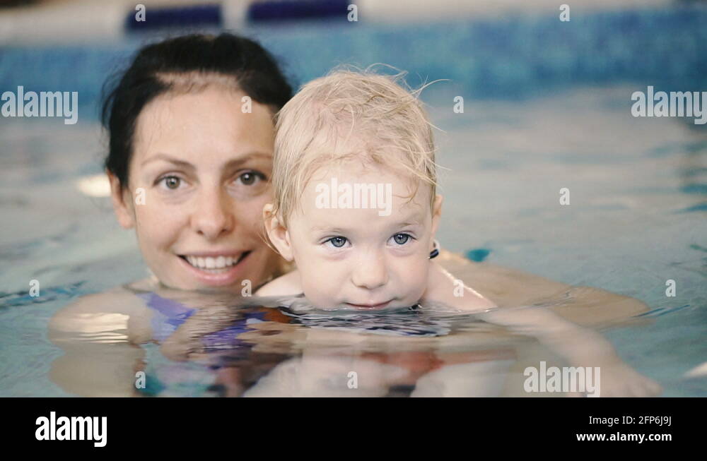 Swimming pool. Mom teaches a young child to swim in the pool Stock ...