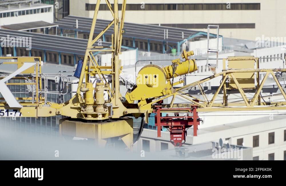 Tower crane and trolley mechanism in action at city construction site ...