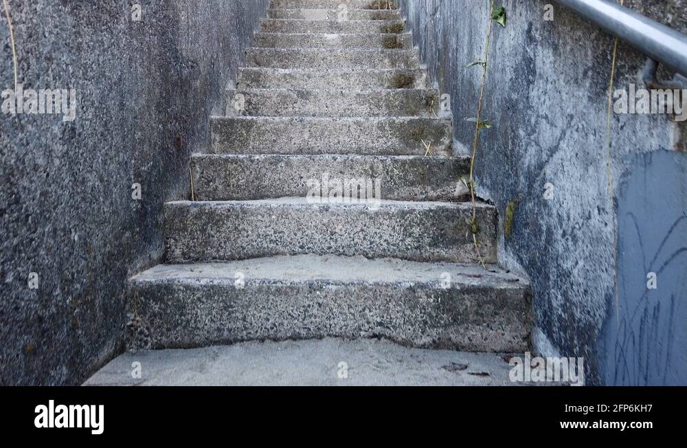 Walking up sandy concrete stairs with a steel handrail at a beach with ...