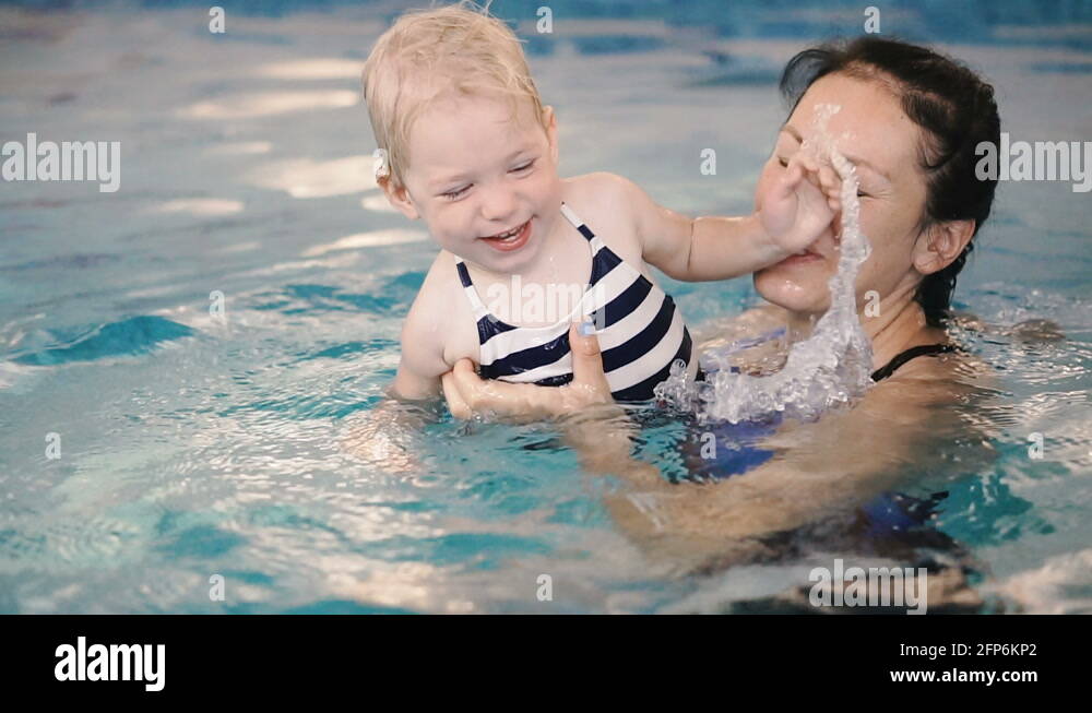 Swimming pool. Mom teaches a young child to swim in the pool Stock ...