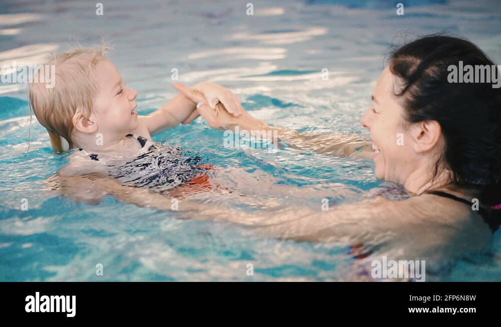 Swimming pool. Mom teaches a young child to swim in the pool Stock ...