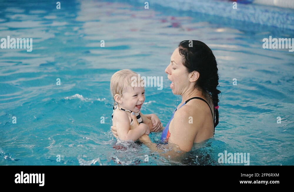 Swimming pool. Mom teaches a young child to swim in the pool Stock ...