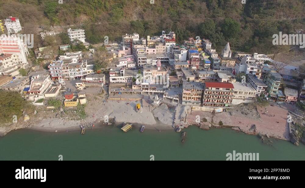 Rishikesh city buildings on Ganges riverbank, India, aerial pan view ...