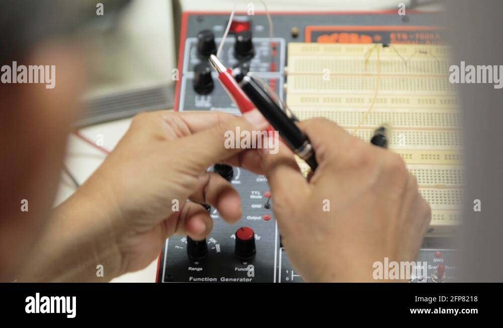 Professor Connecting an Electrical Circuit to a Breadboard in a ...