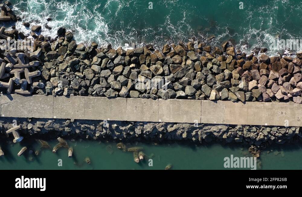 Jetty fortified with rocks and cement to prevent erosion. Drone top ...